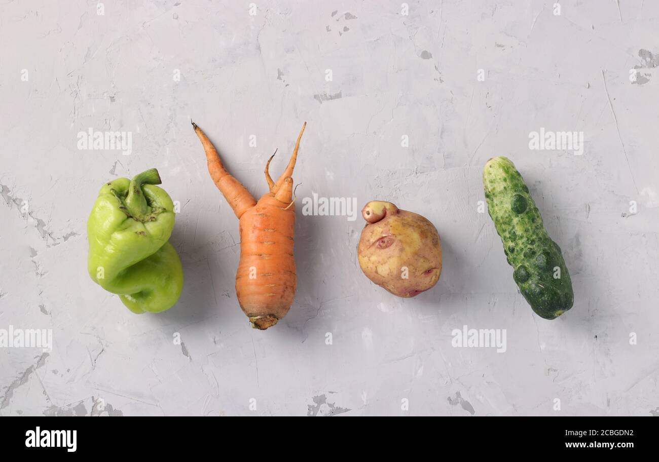 Ugly vegetables: pepper, carrot, potato and cucumber on light gray ...