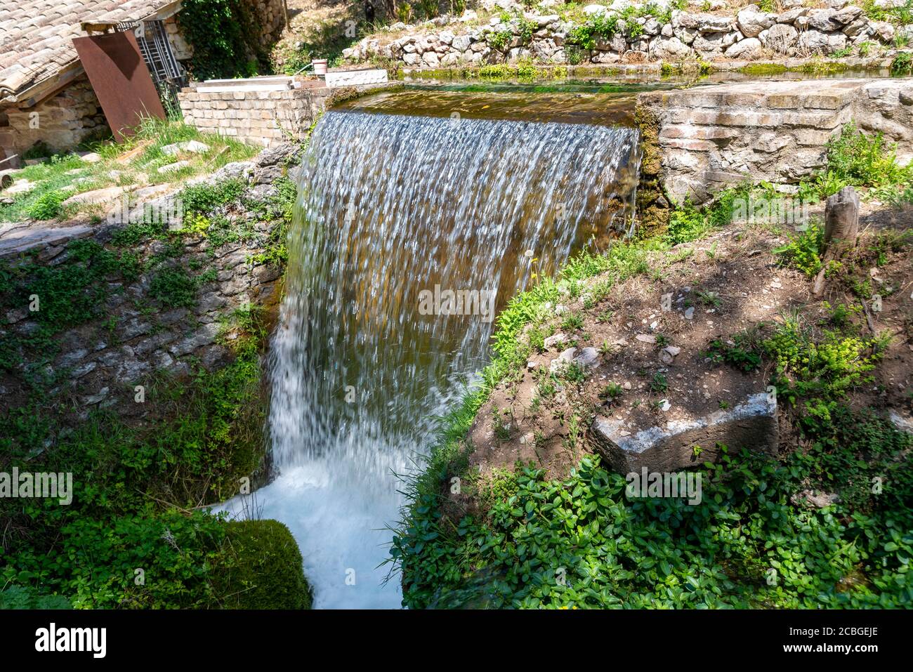 Piccolo makes water and forms a small waterfall on a sunny day Stock ...