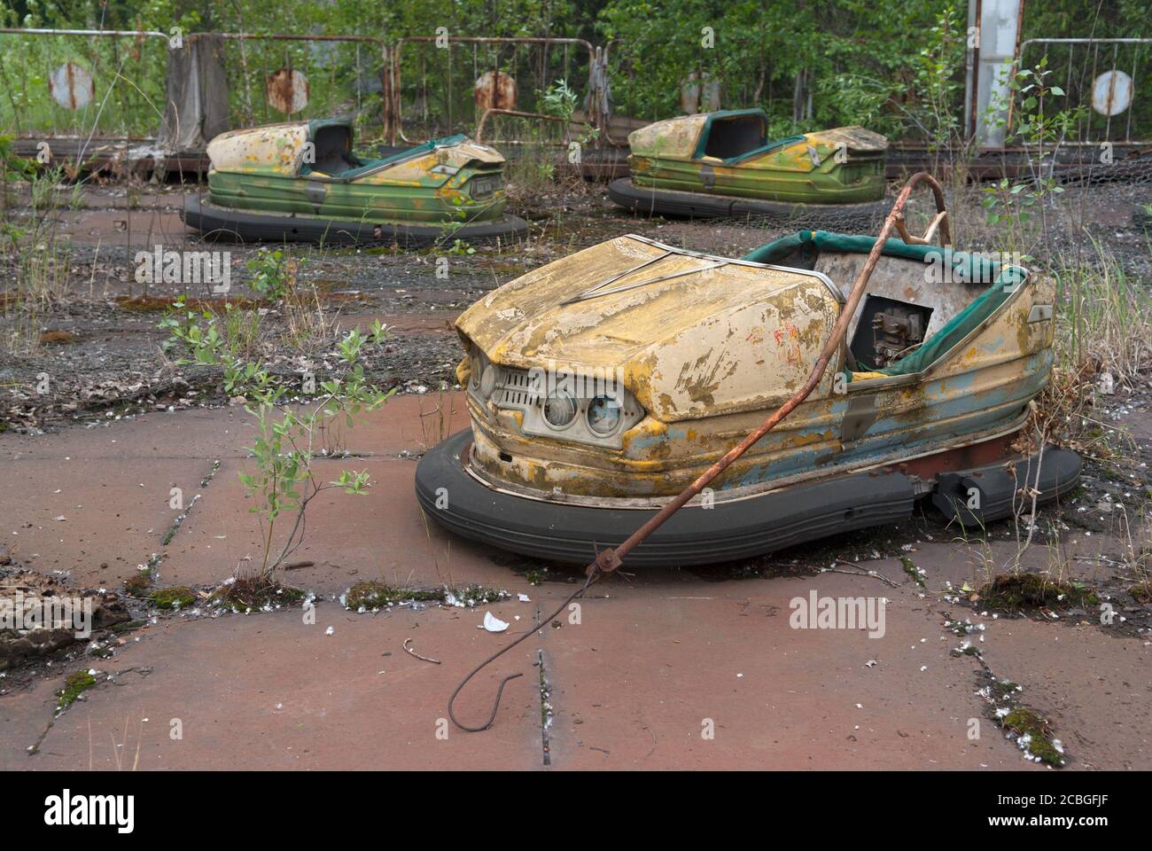 Old broken rusty metal radioactive yellow cars, children in Pripyat ...