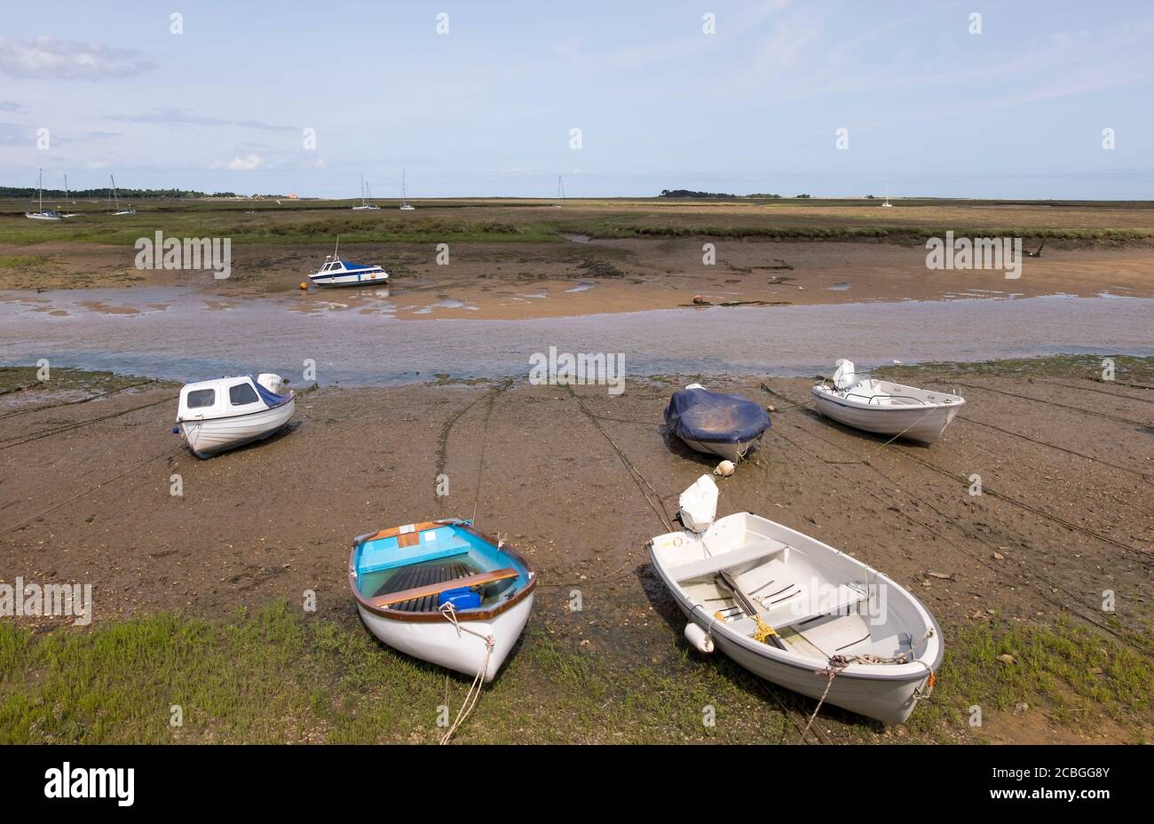 Small boats stranded on wet sand at low tide Stock Photo - Alamy