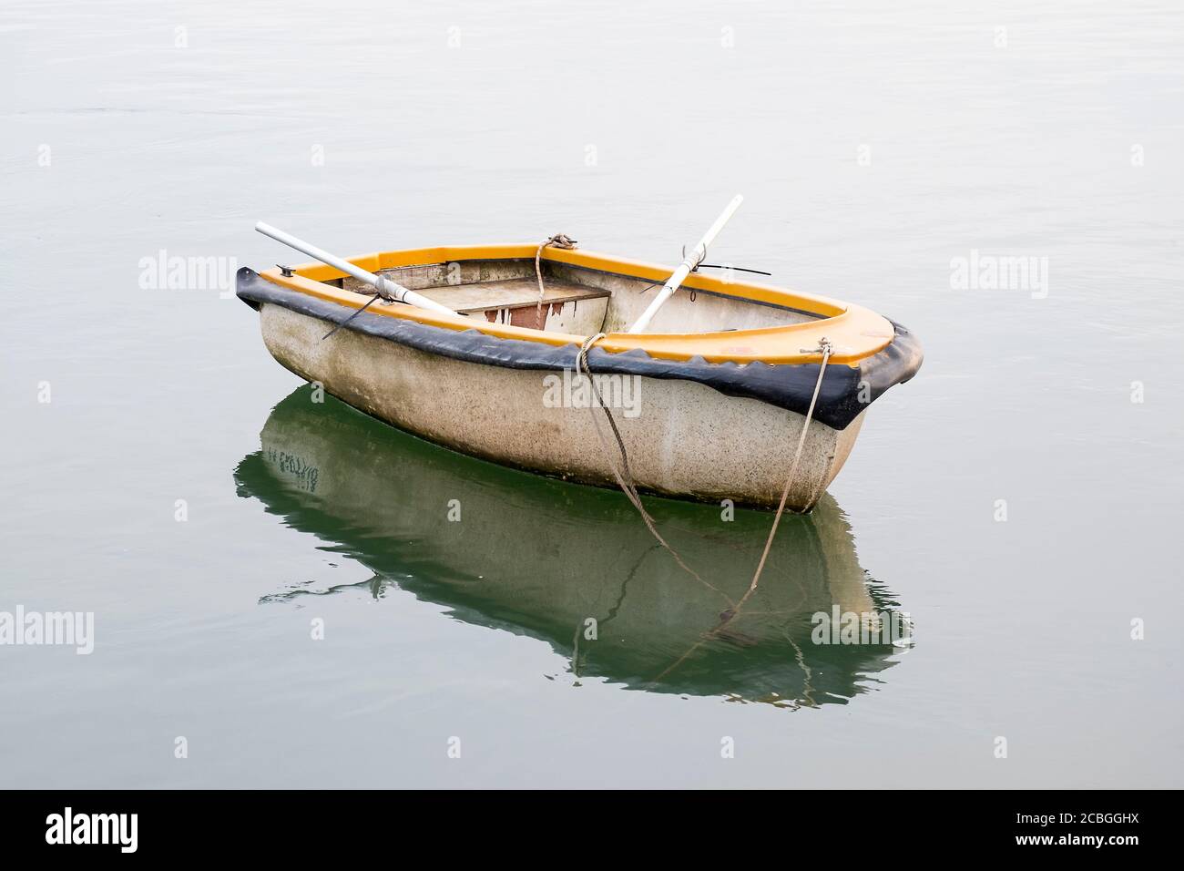 Small row boat anchored on a high tide Stock Photo - Alamy