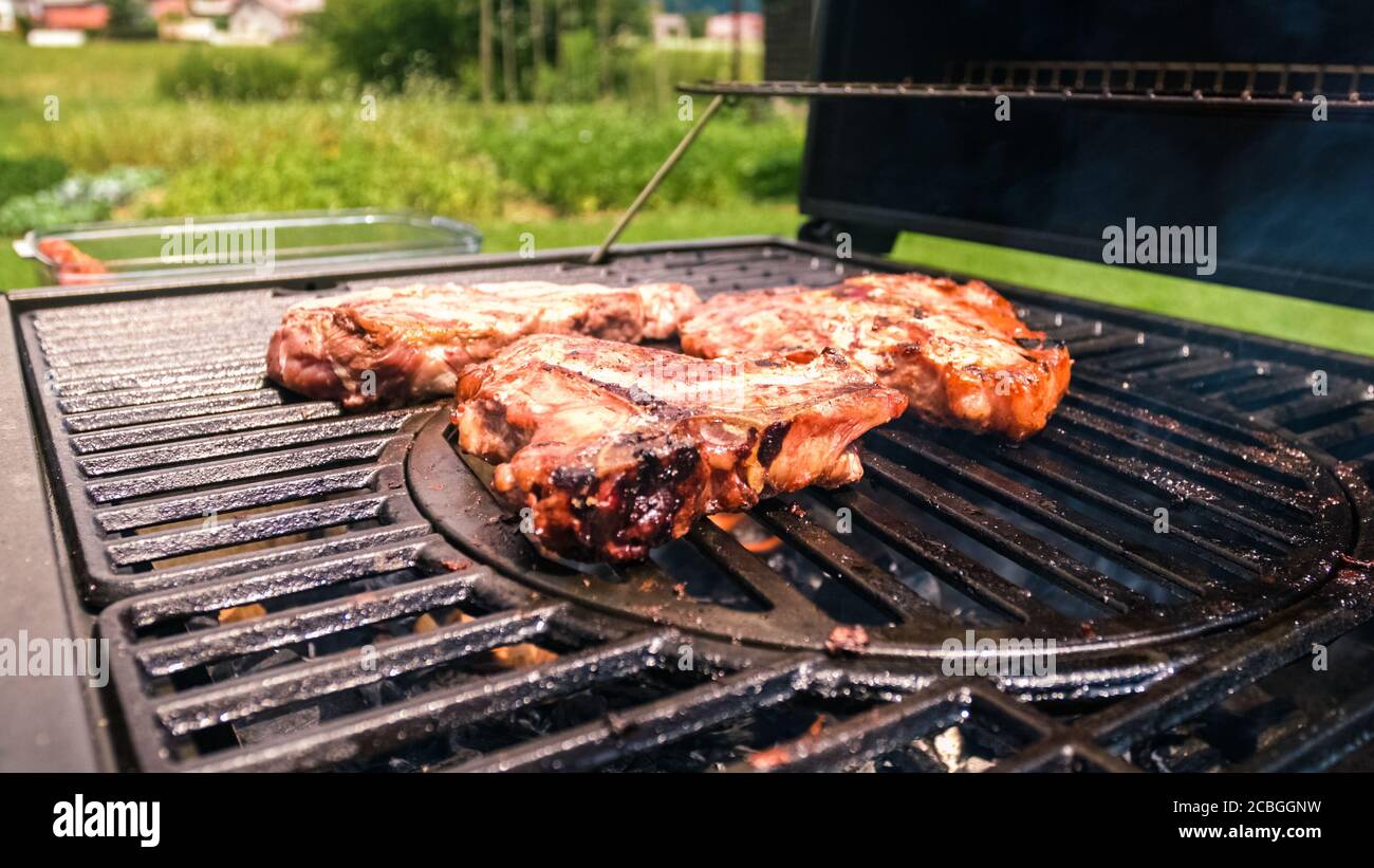 Home barbecue with charcoal in the backyard grilling steaks and other ...
