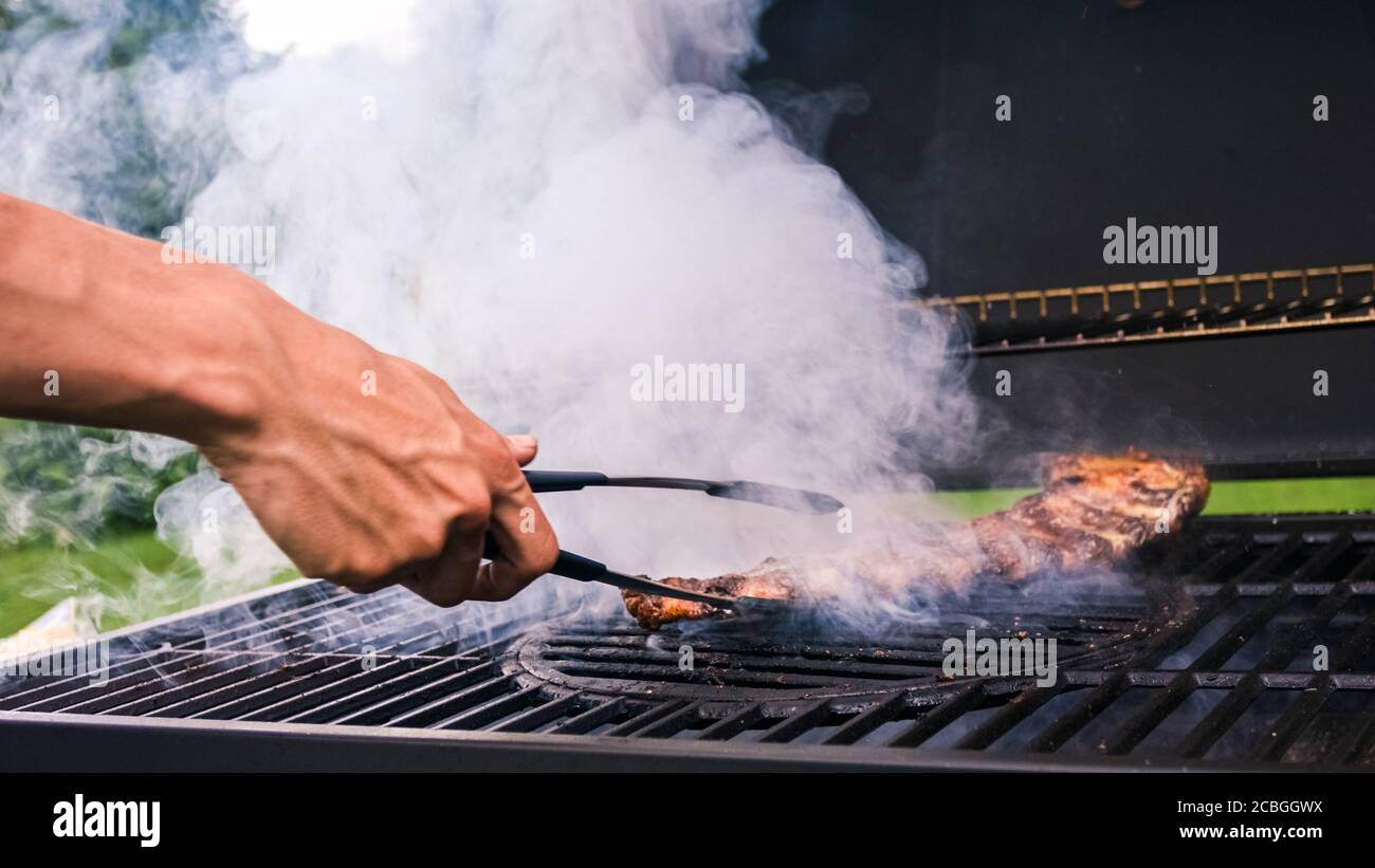 Home barbecue with charcoal in the backyard grilling steaks and other ...