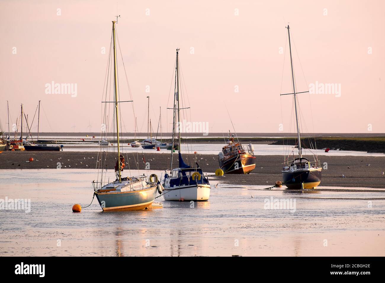 Small boats at dawn on a high tide Stock Photo - Alamy