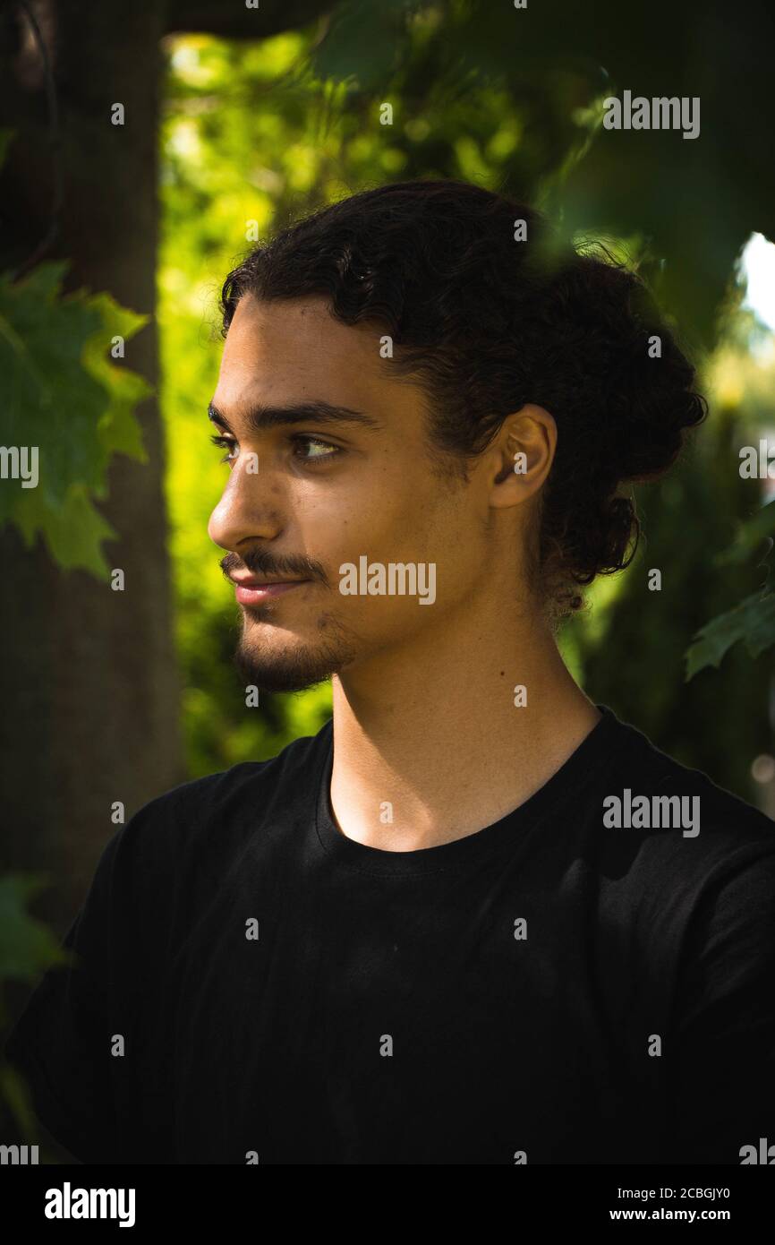 A vertical shallow focus closeup shot of a Hispanic male with long hair ...
