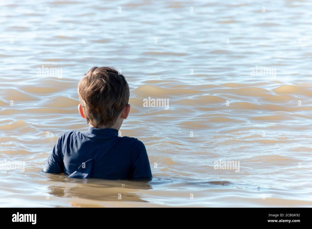 a close up view of a small boy floating in the shallow water in the ...