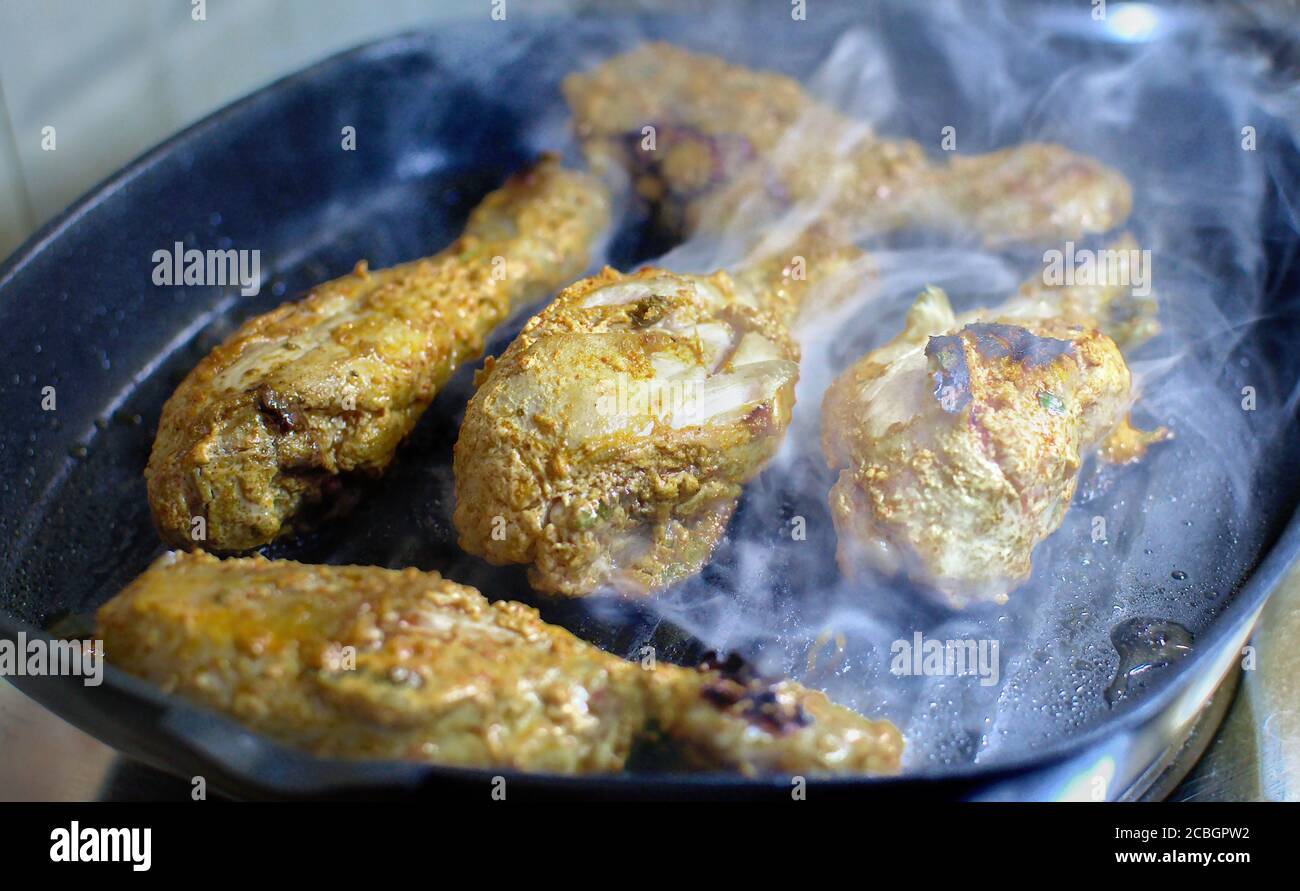 Smokey Chicken tangdi or Tangri kebab or kabab being cooked in a grill ...