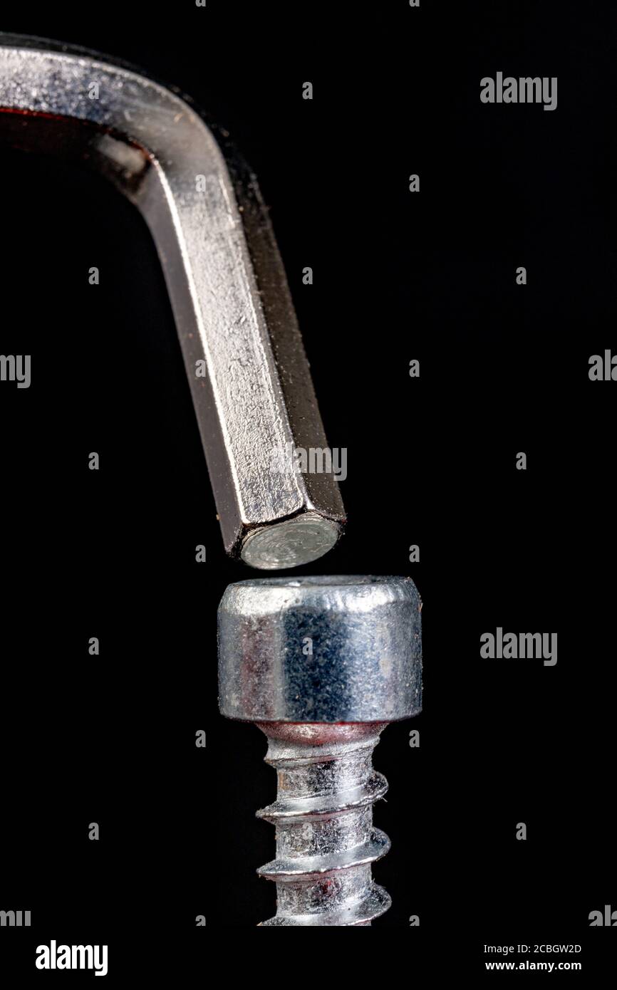Allen screws and wrench on a dark table. Accessories for assembling ...
