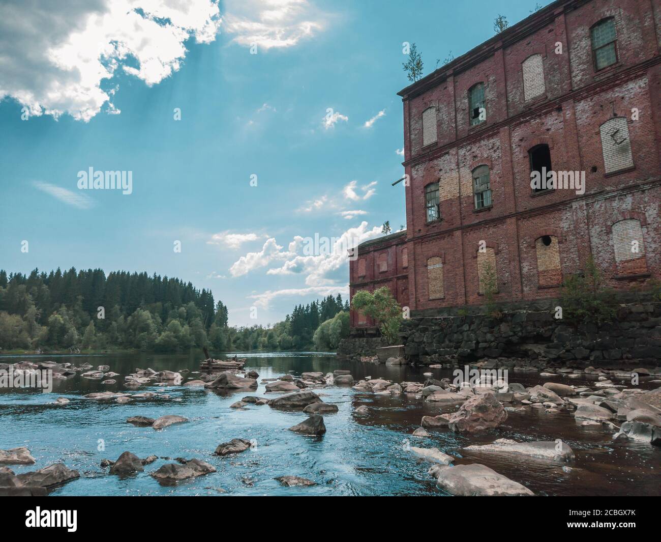 Abandoned factory on the water edge. old building on the rocky river ...