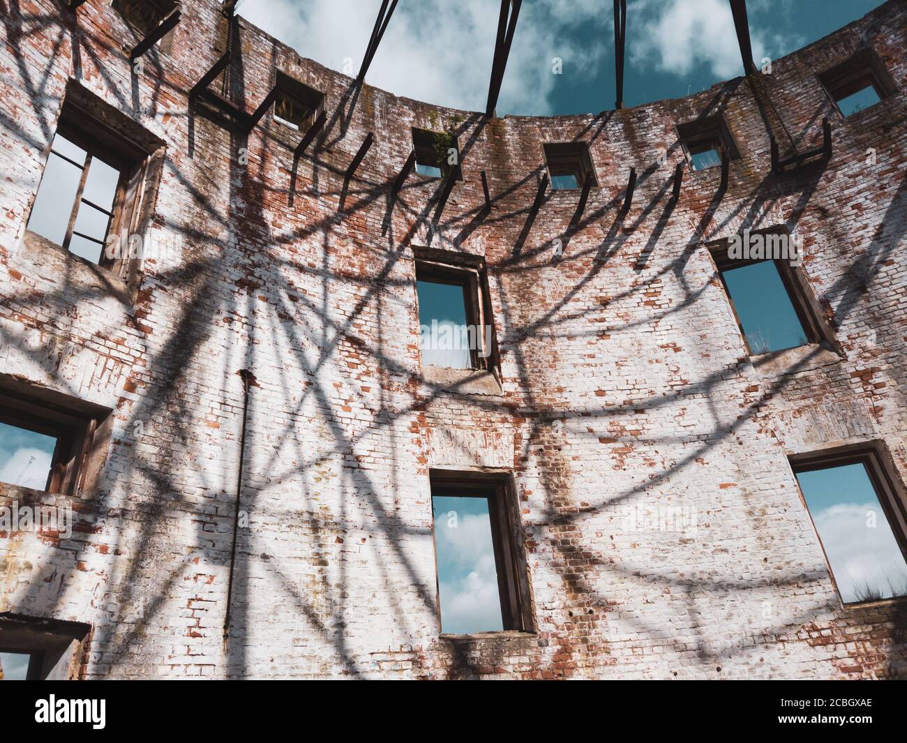 Curved brick wall of ruined building. sky is visible through the ...