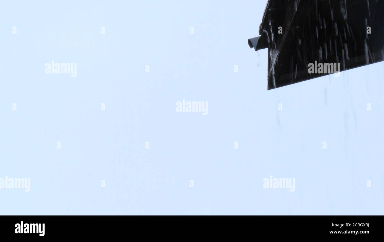 Rain drops falling from roof's eave during rain Stock Photo - Alamy