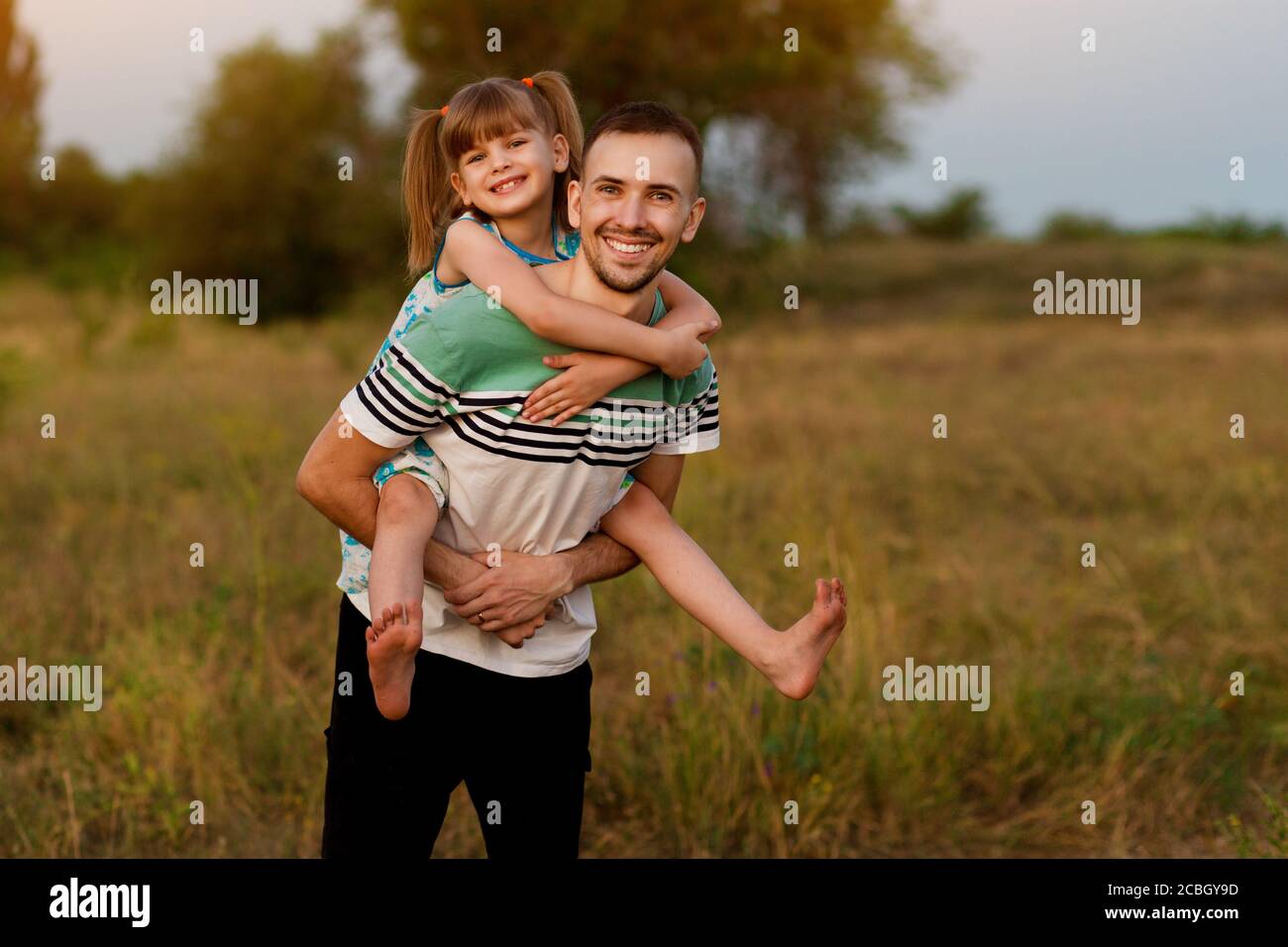 Beautiful little girl hugging embracing her father in summer outdoor ...