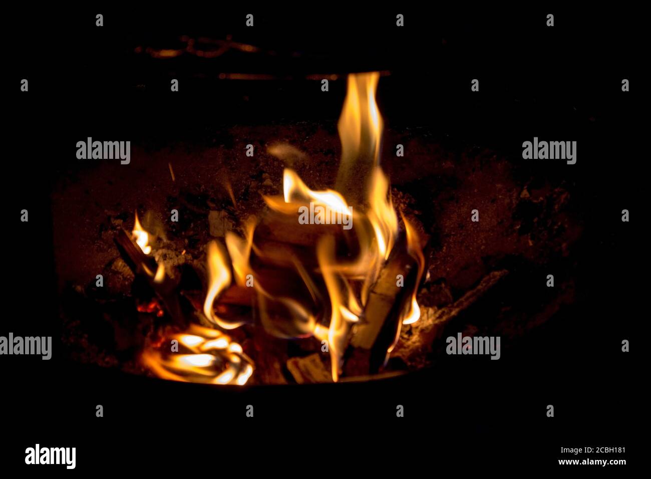 Fire flames and red-hot wooden logs in the dark Stock Photo - Alamy
