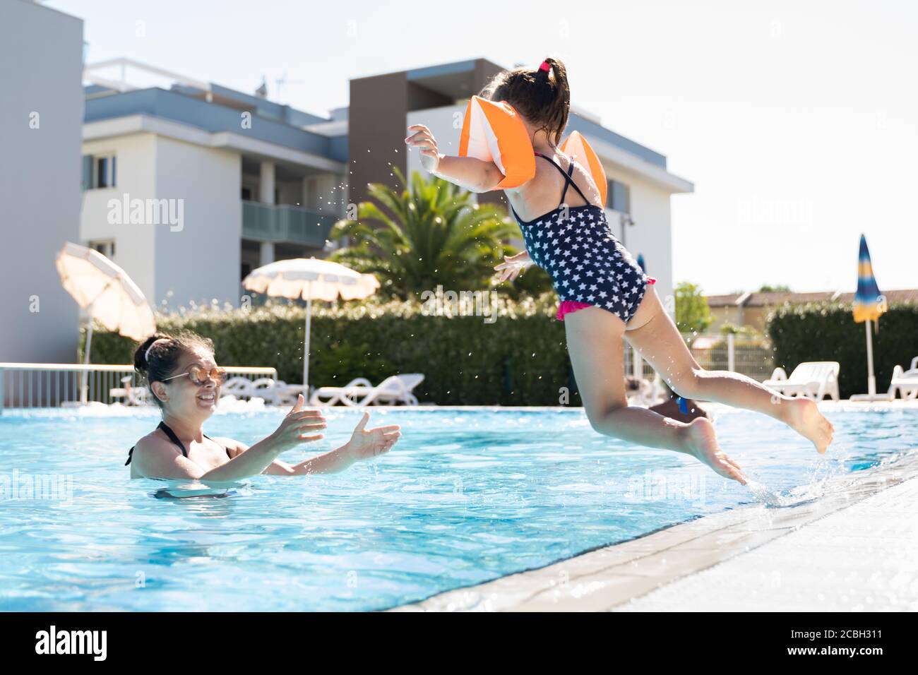 Mother daughter jumping swimming pool hi-res stock photography and ...