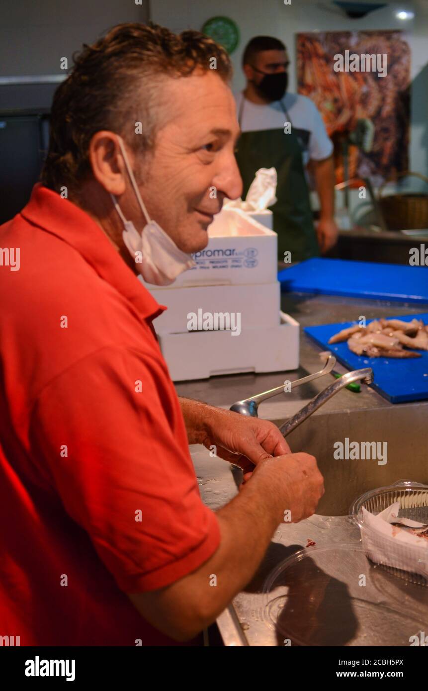 Italy - August 2020 at the fish market butcher works cleaning and ...