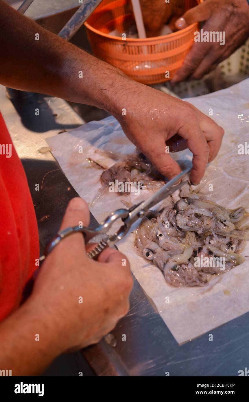 Italy - August 2020 at the fish market butcher works cleaning and ...