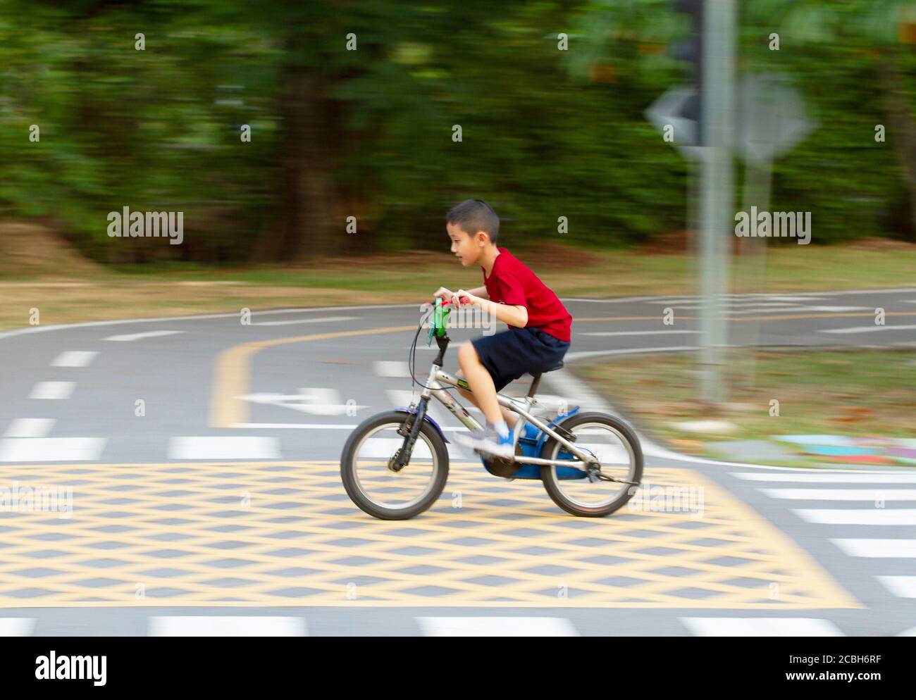 Asian boy riding bicycle in the park (motion blurred Stock Photo - Alamy