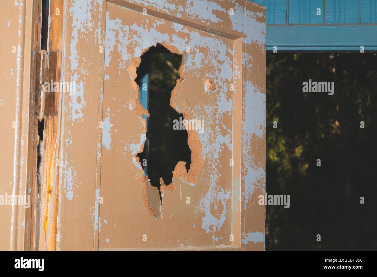 Hole in a broken door in a ruined house. abandoned building Stock Photo ...