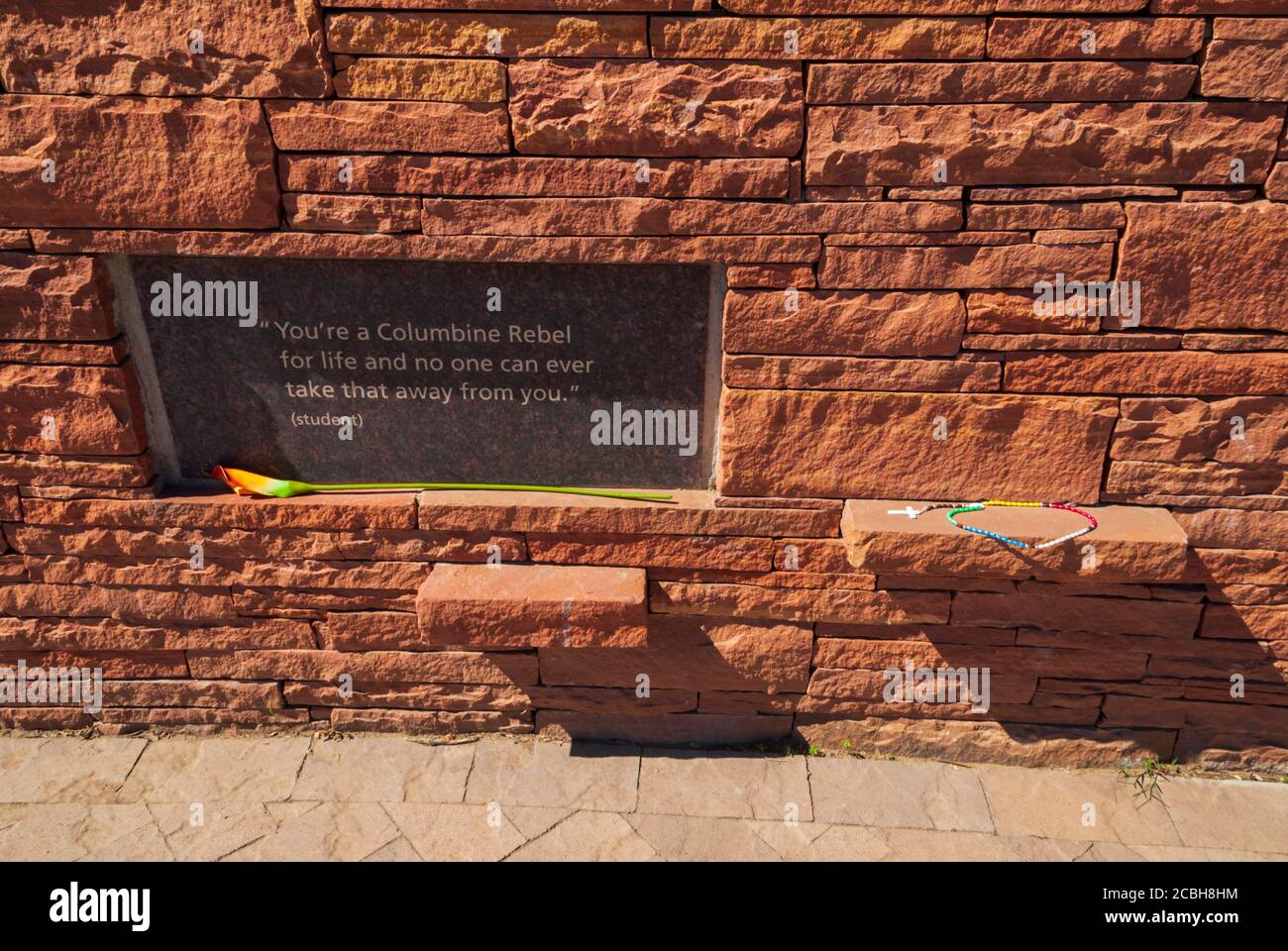 A lily flower and rosary are left at a close-up section of the ...