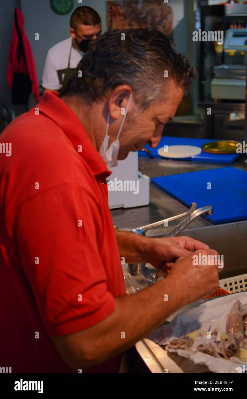 Italy - August 2020 at the fish market butcher works cleaning and ...