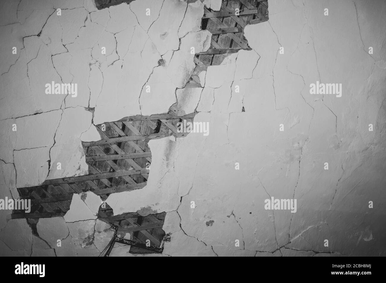 Dilapidated ceiling of an old house. damaged wall with a hole with ...