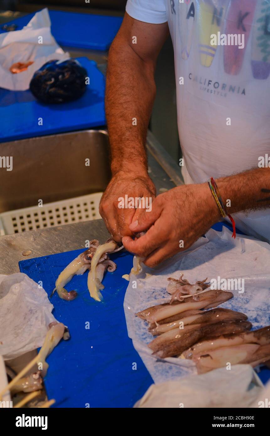 Italy - August 2020 at the fish market butcher works cleaning and ...