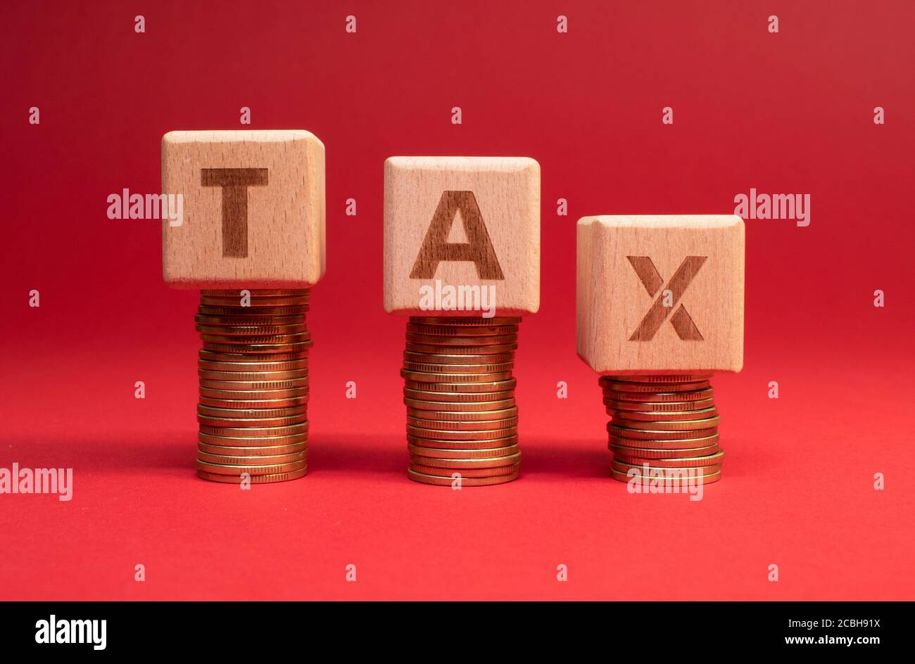 Tax reduction concept with wooden blocks and coins Stock Photo - Alamy