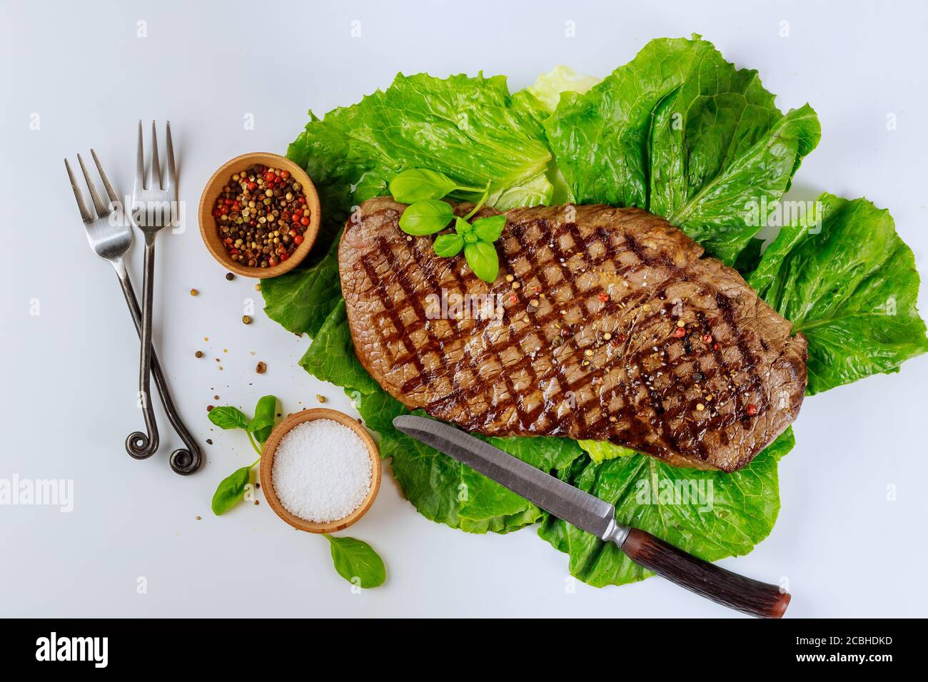 Tasty grilled beef lion with spices and knife on white isolated ...