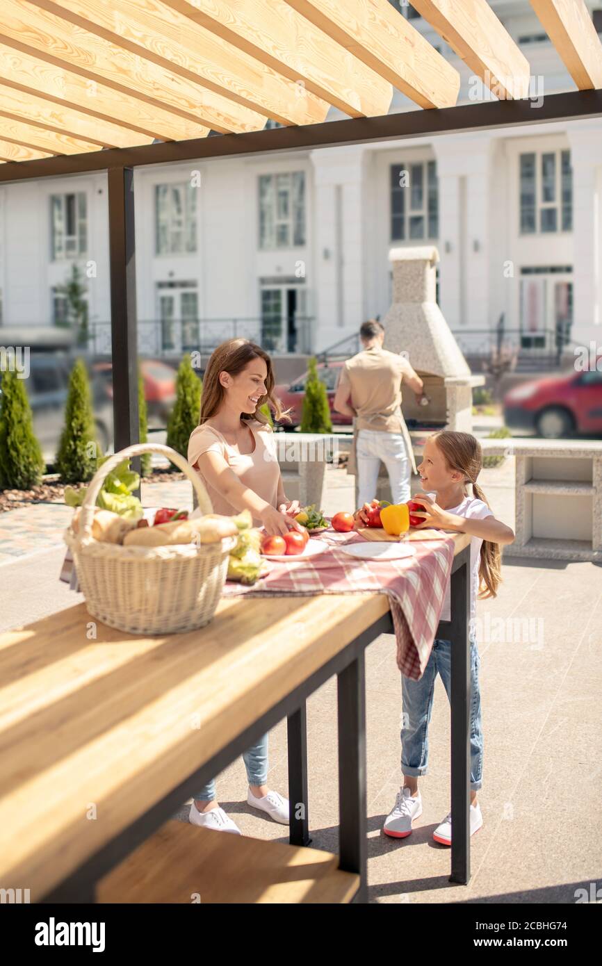 Daughter and mom getting the table ready for dinner Stock Photo - Alamy