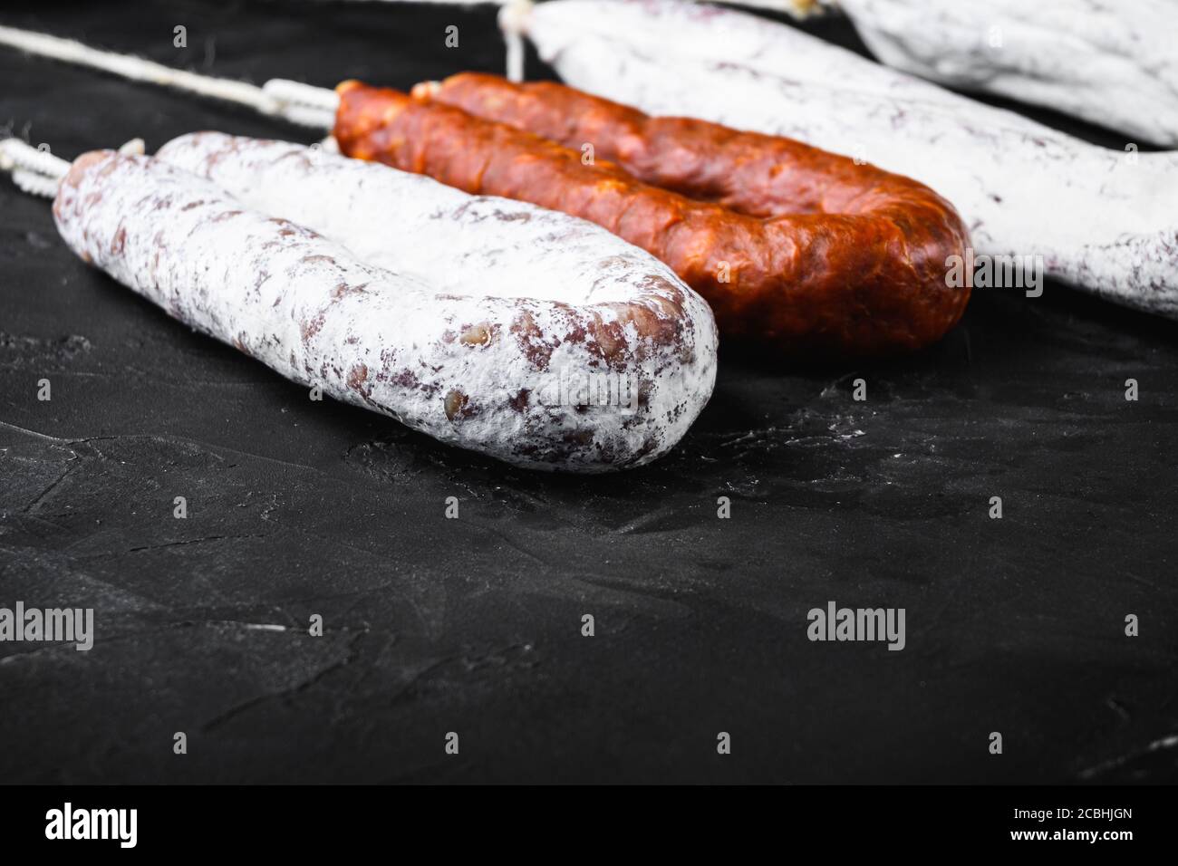Traditional spanish sausages fuet and chorizo on black textured ...