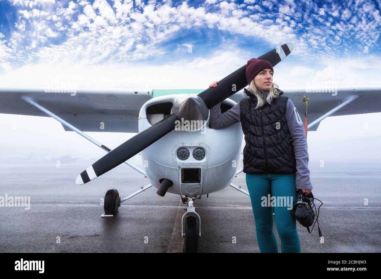Young Caucasian Female Student Pilot is standing in front of a Single ...
