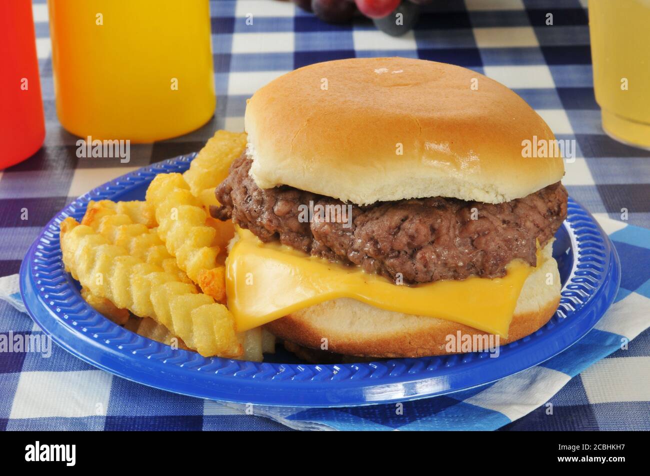 A cheeseburger and fries on a picnic table with fries Stock Photo - Alamy