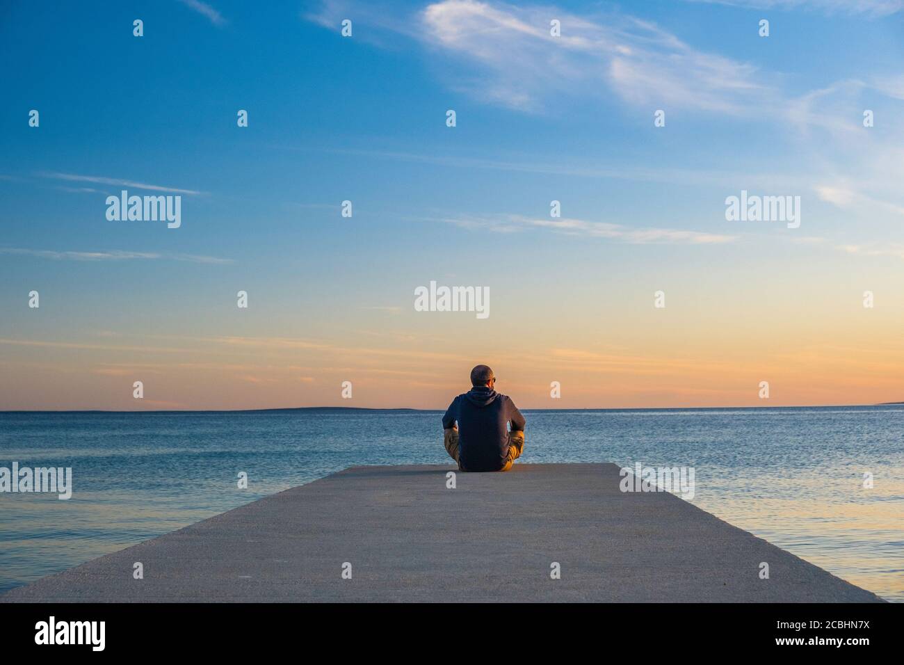 Man sitting on dock hi-res stock photography and images - Alamy