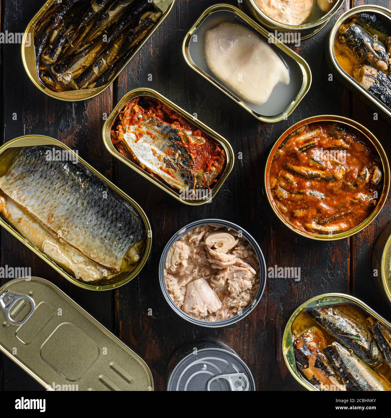 Cans of canned with different types of fish and seafood, over rustic ...