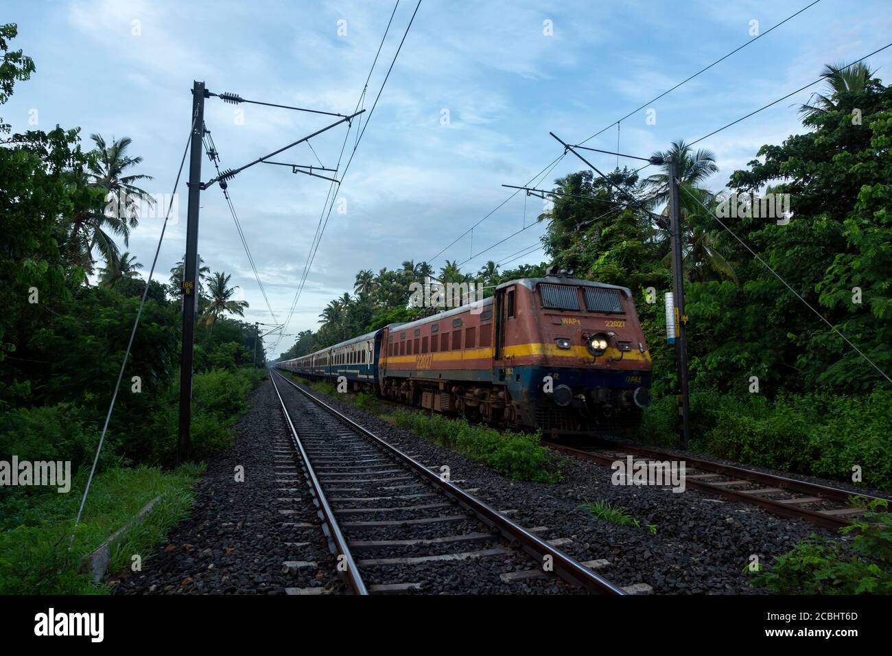 A train moving with electric support through the track in Indian ...