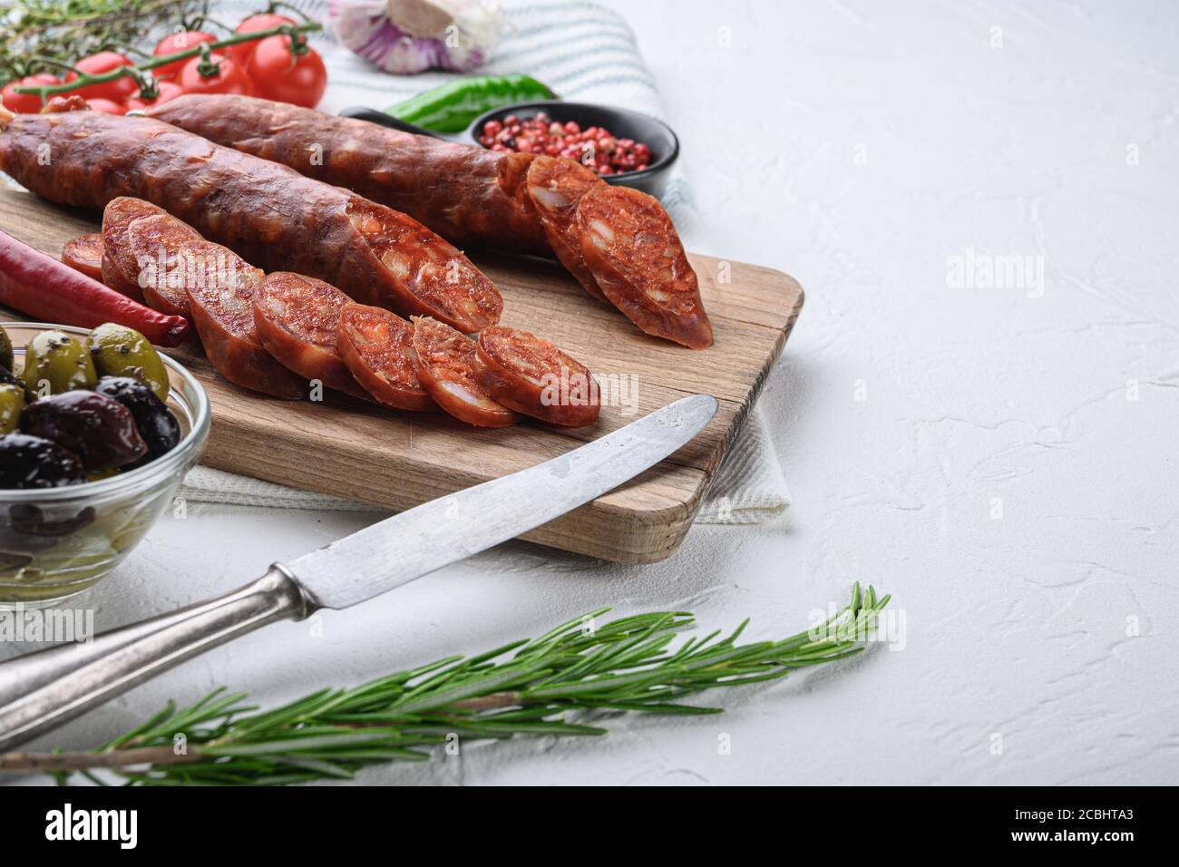 Traditional chorizo cuts with spices and ingredients on white textured ...