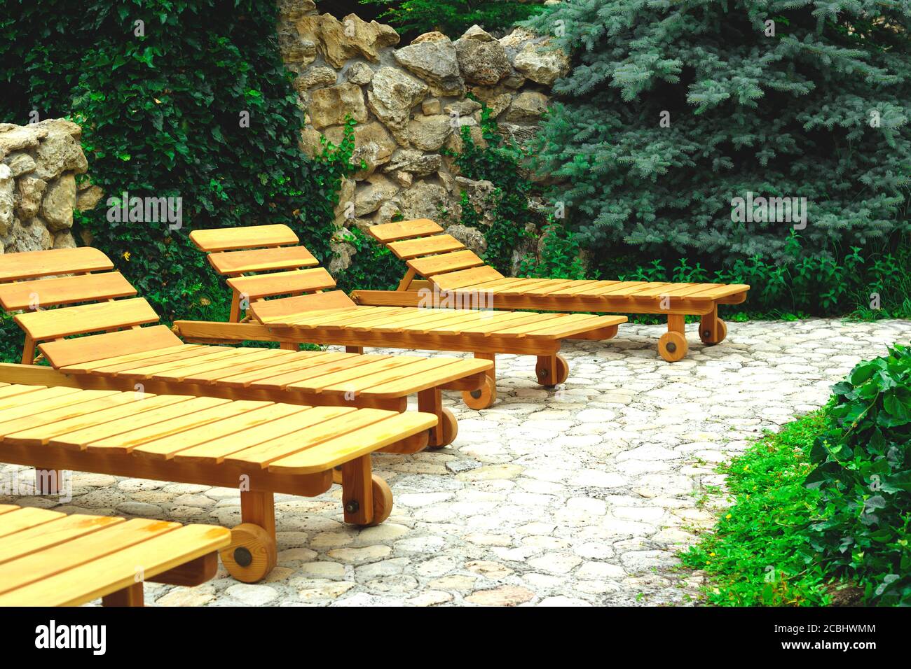 relaxation area with wooden sunbeds surrounded by lush greenery Stock ...