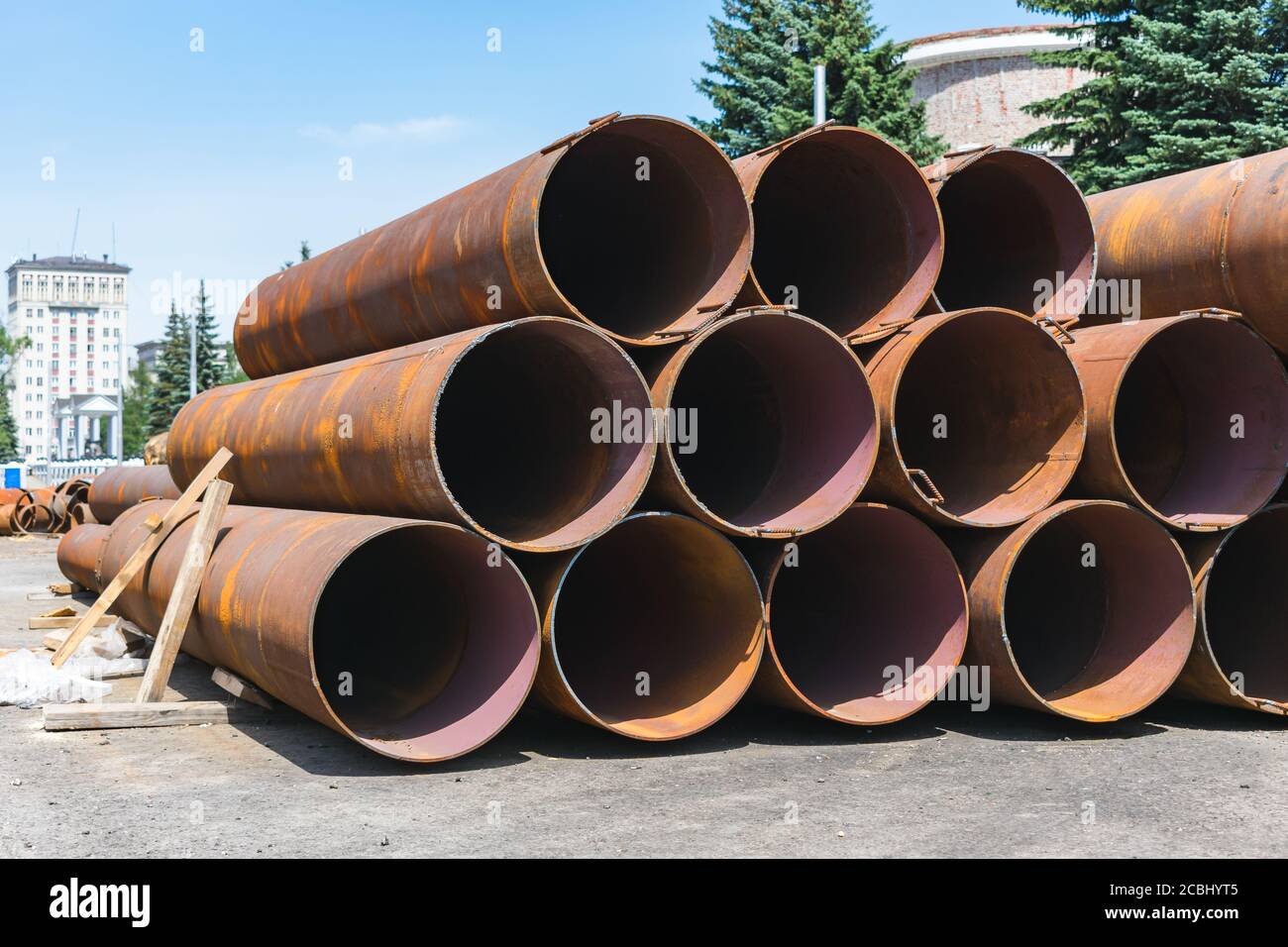 Large, old and rusty sewer pipes stacked in one batch for recycling ...
