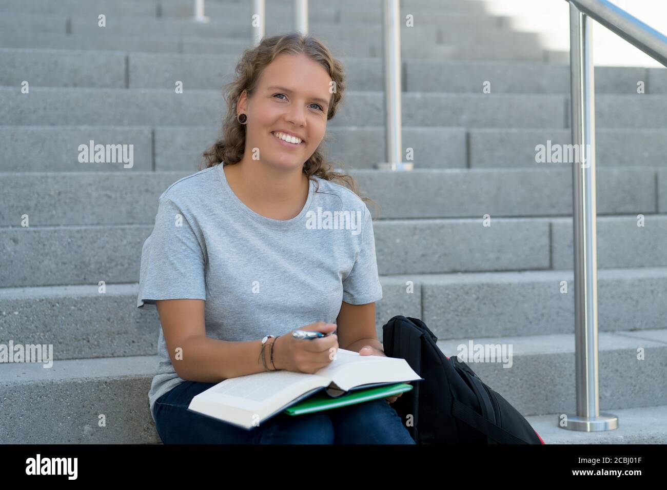 Learning german female student preparing for graduation outdoors in ...