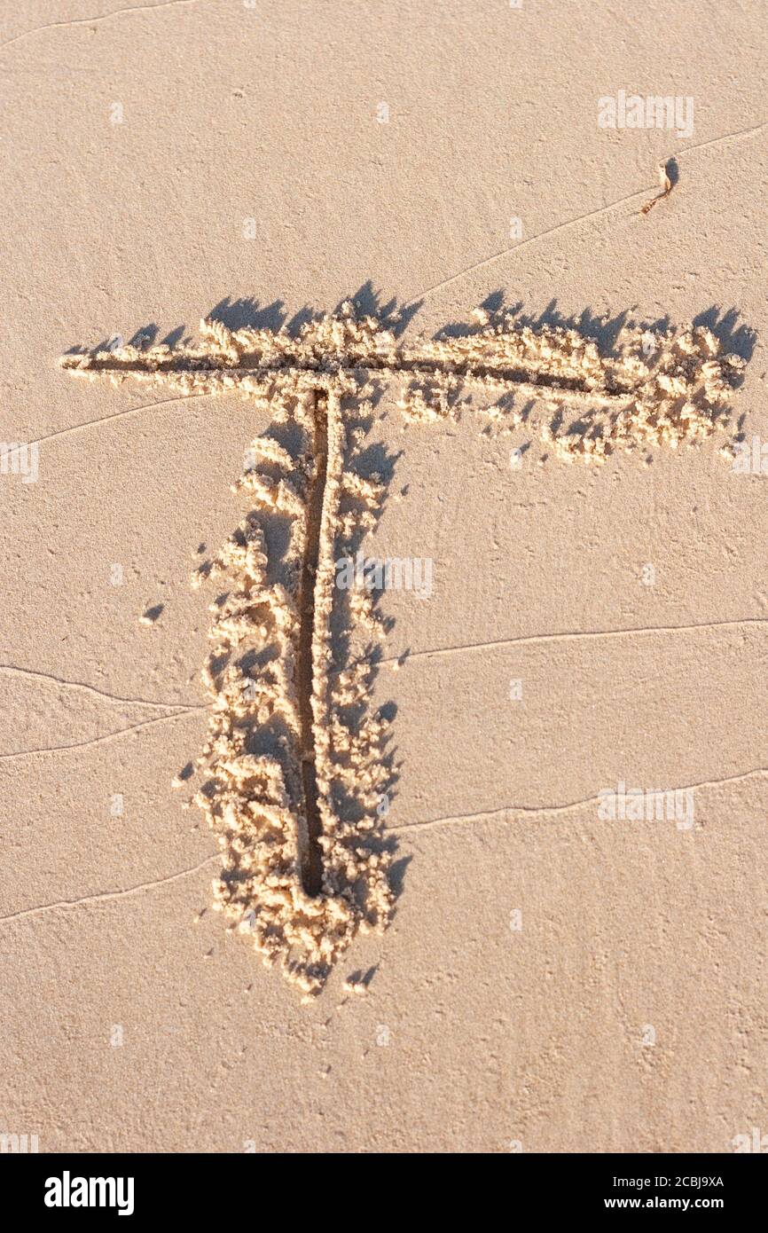T - Alphabet letter written on sand Stock Photo - Alamy