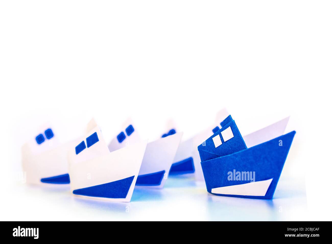 Leadership concept with blue paper ship leading among white Stock Photo ...