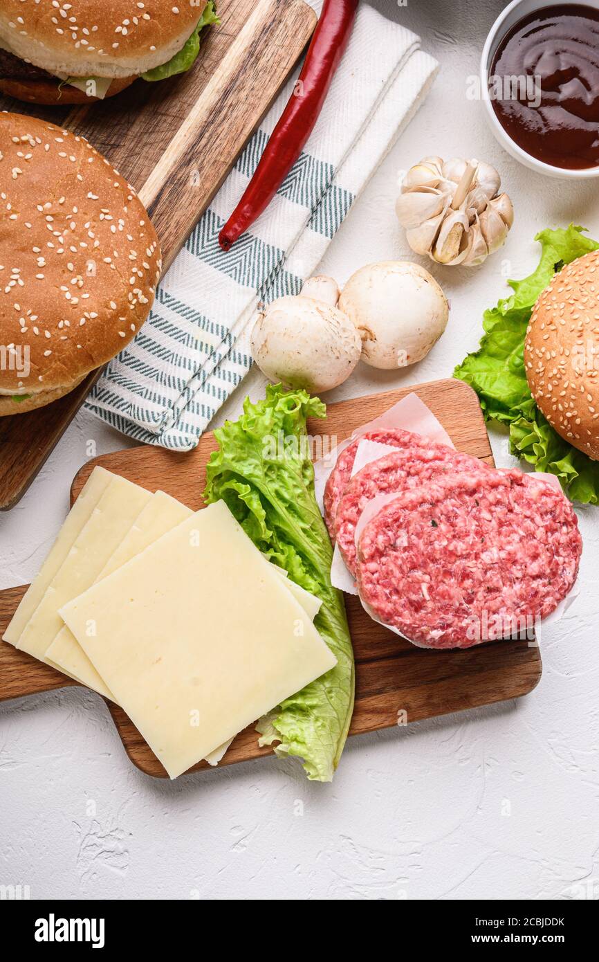 Set of burger raw ingredients and ground beef on white textured ...