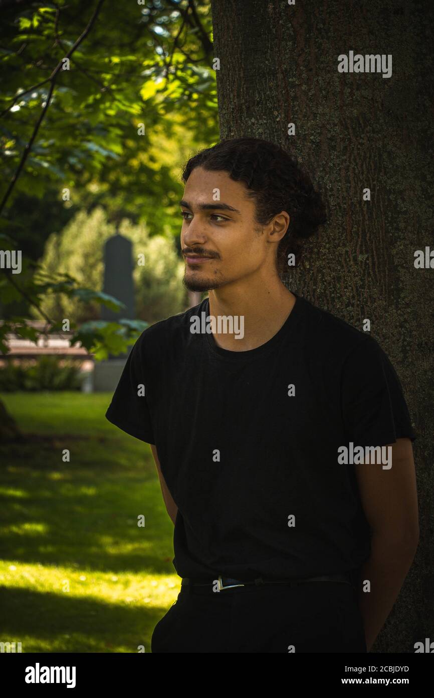 A vertical shallow focus closeup shot of a Hispanic male with long hair ...
