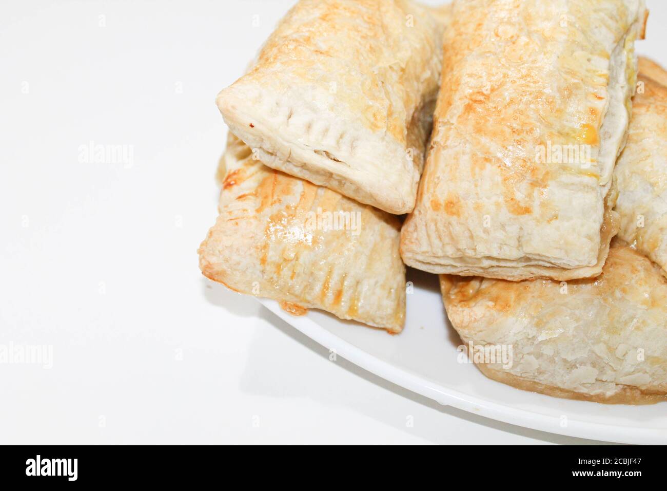 Fresh baked puff pastries on a white plate. Rich pastries on the table ...
