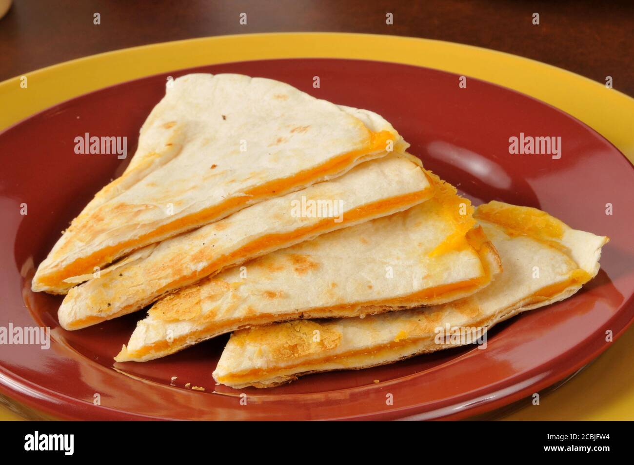Closeup of cheese quesadillas on colorful plates Stock Photo - Alamy