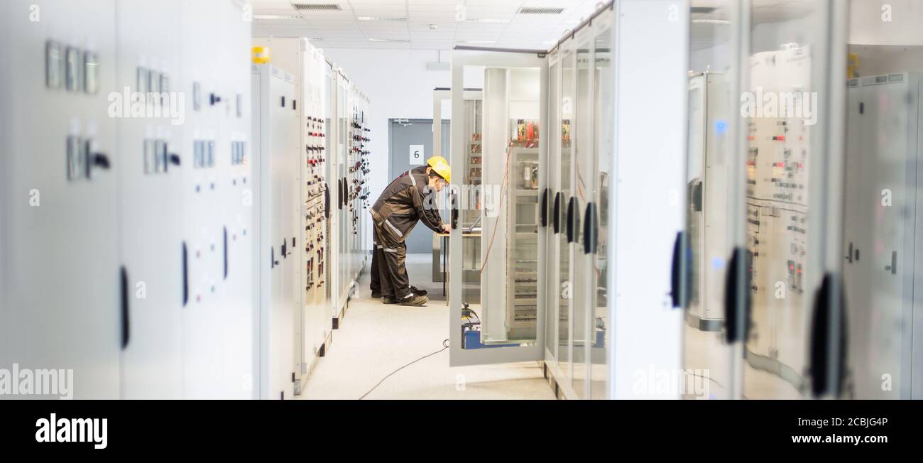 Two maintenance engineer work on relay protection system. Bay control ...