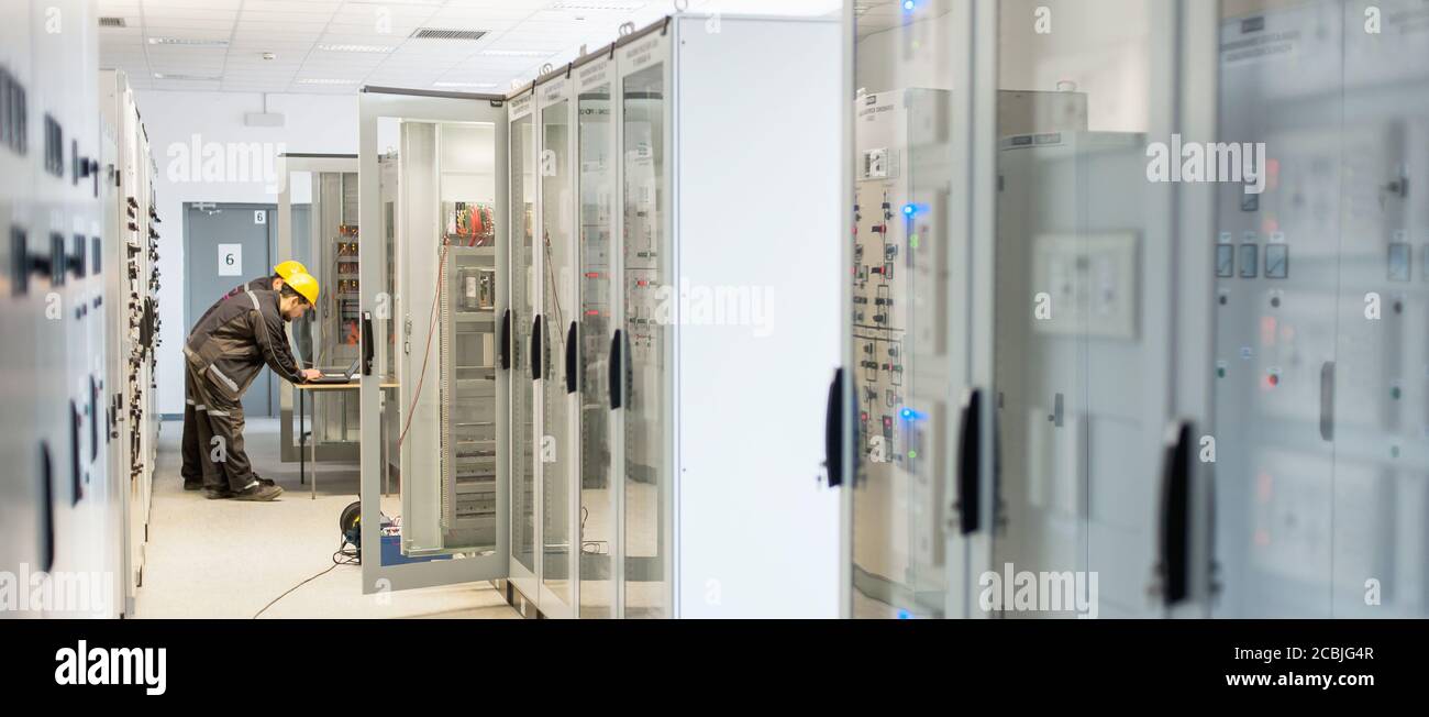 Two maintenance engineer work on relay protection system. Bay control ...