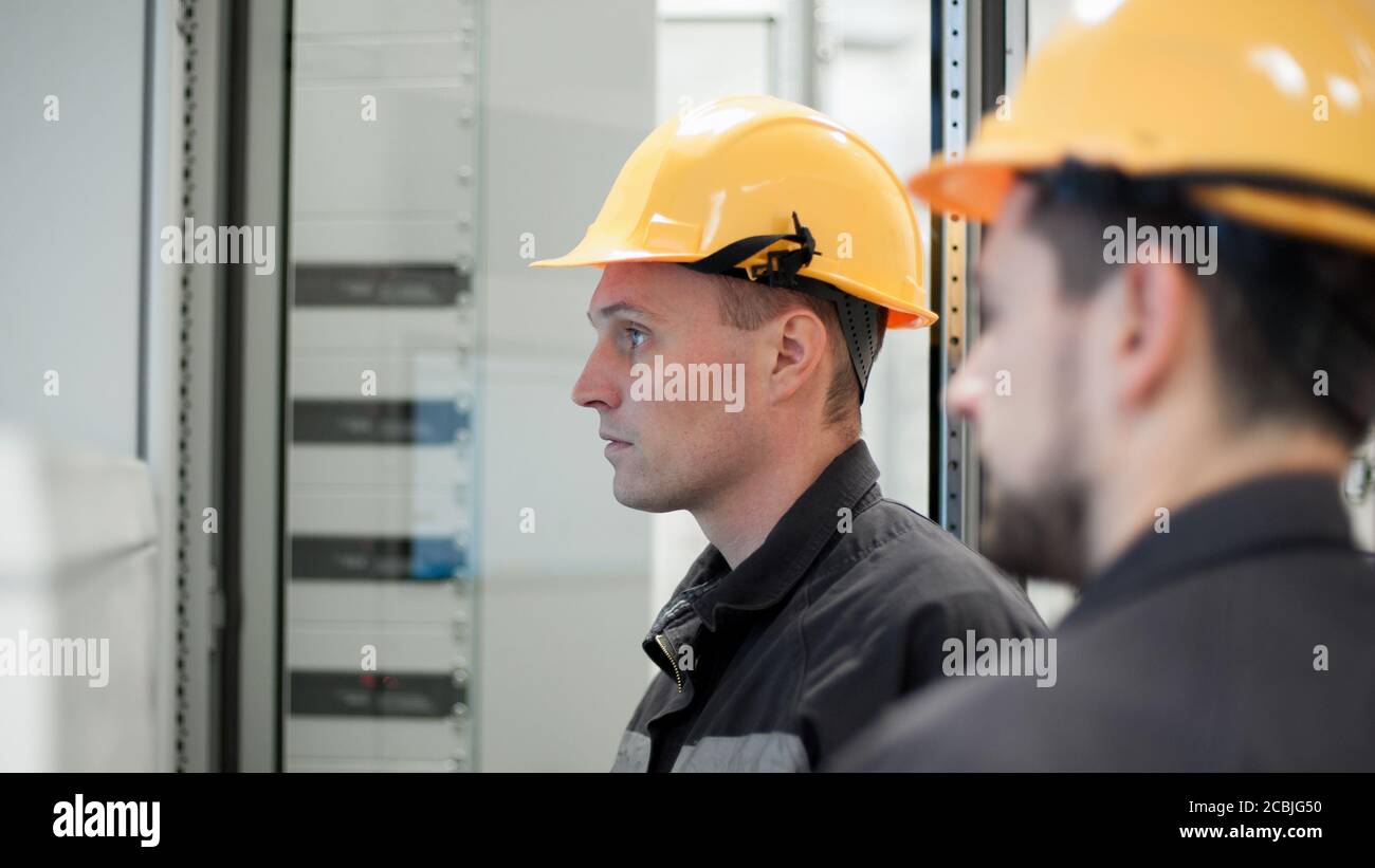 Two maintenance engineer work on relay protection system. Bay control ...
