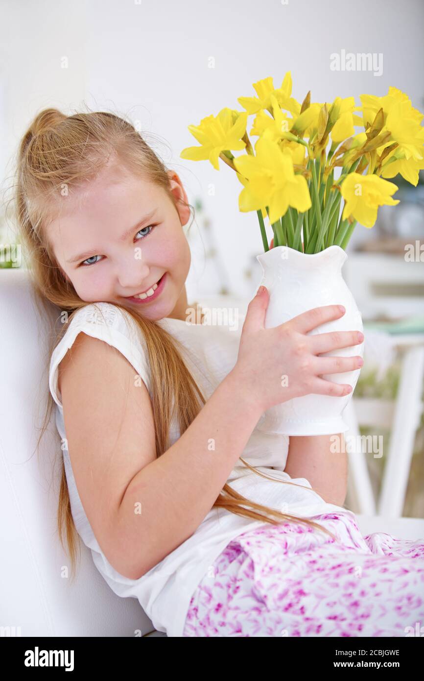 Happy child holds a vase with a lot of yellow daffodils Stock Photo - Alamy