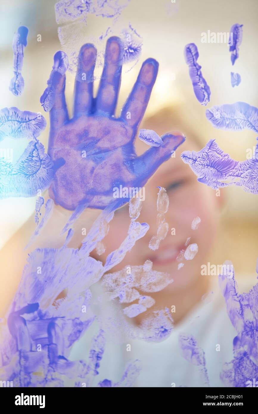 Happy child paints many handprints by hand on a window Stock Photo - Alamy